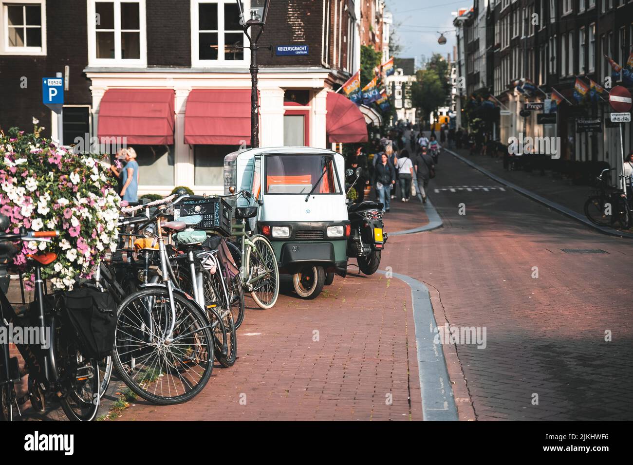 A beautiful shot of a street in Amsterdam with parked vehicles on a ...