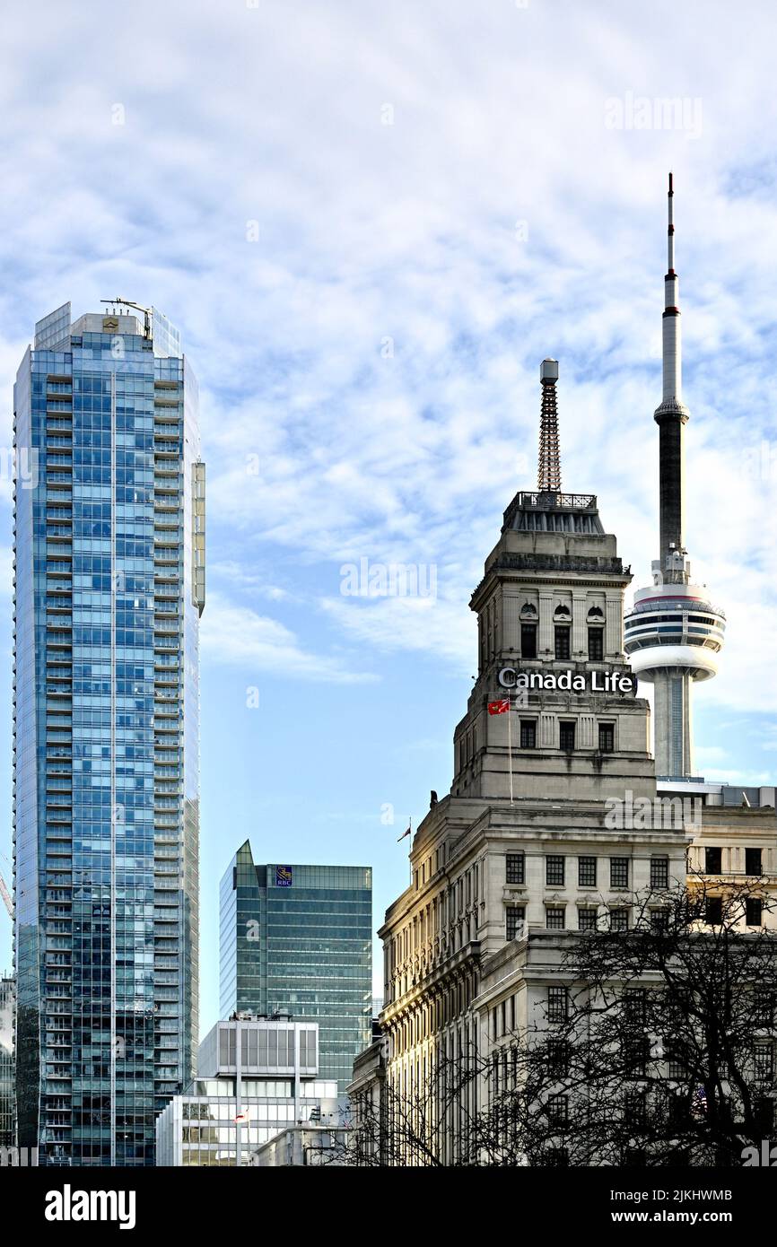 A vertical shot of the Canada Life building and the CN tower in cloudy ...