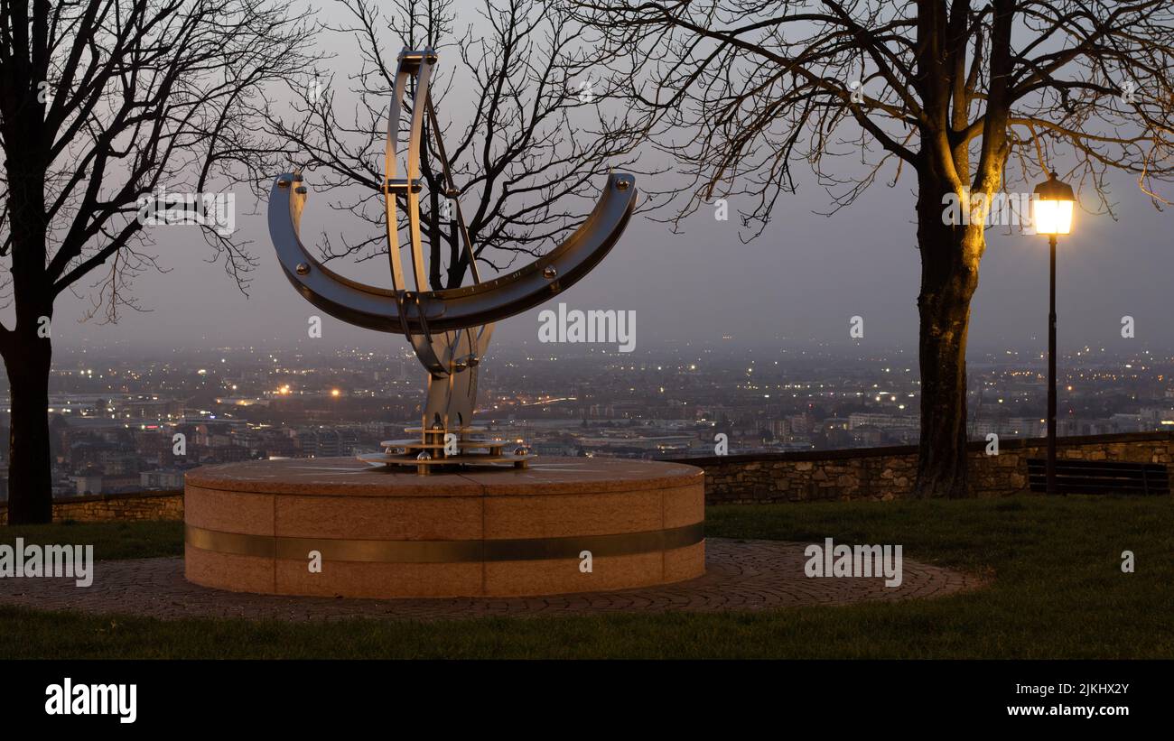 A beautiful night shot of a modern sundial in a park in Bergamo with ...