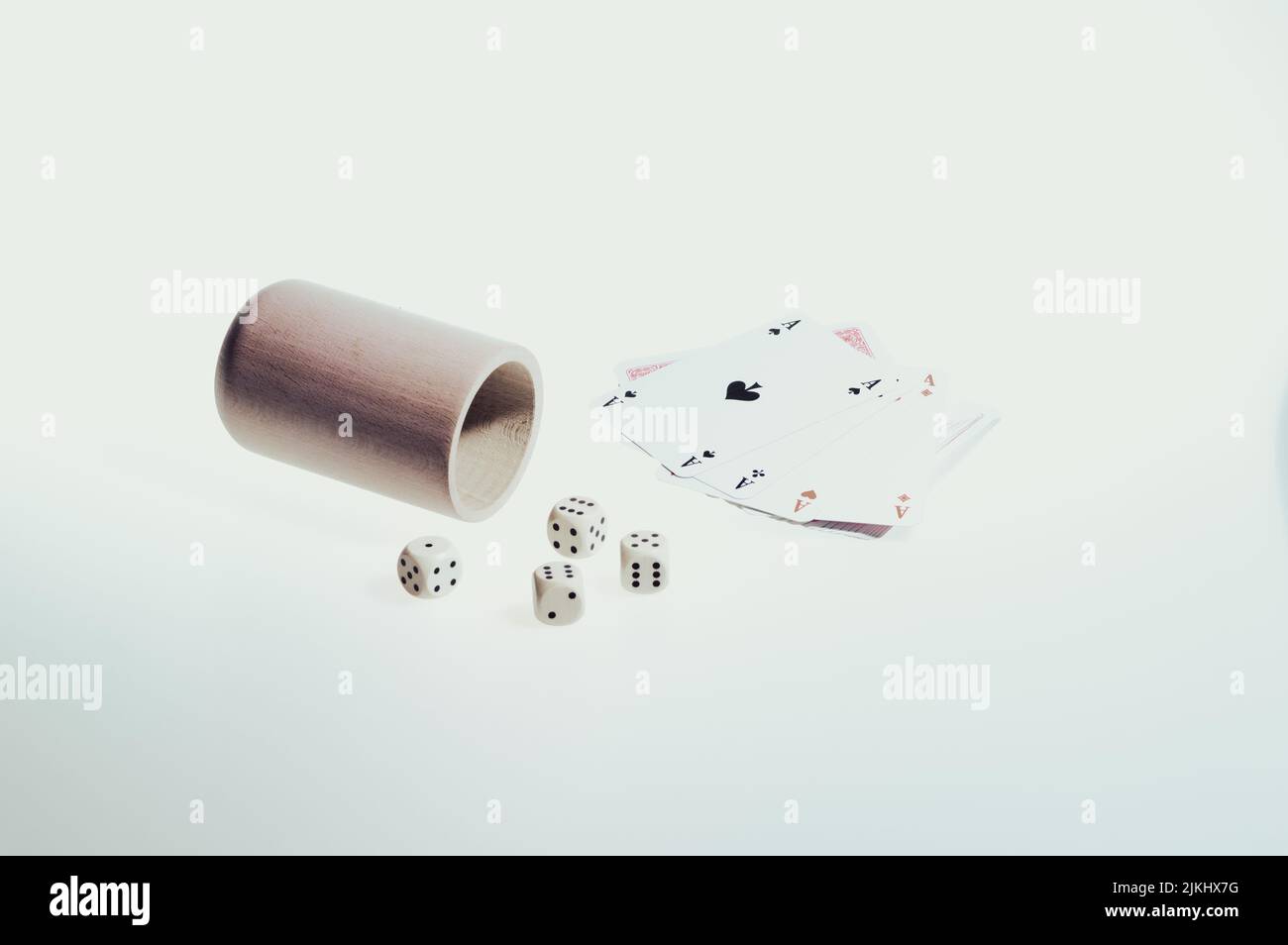 Some playing cards and some dice next to a wooden dice stirrer on a ...