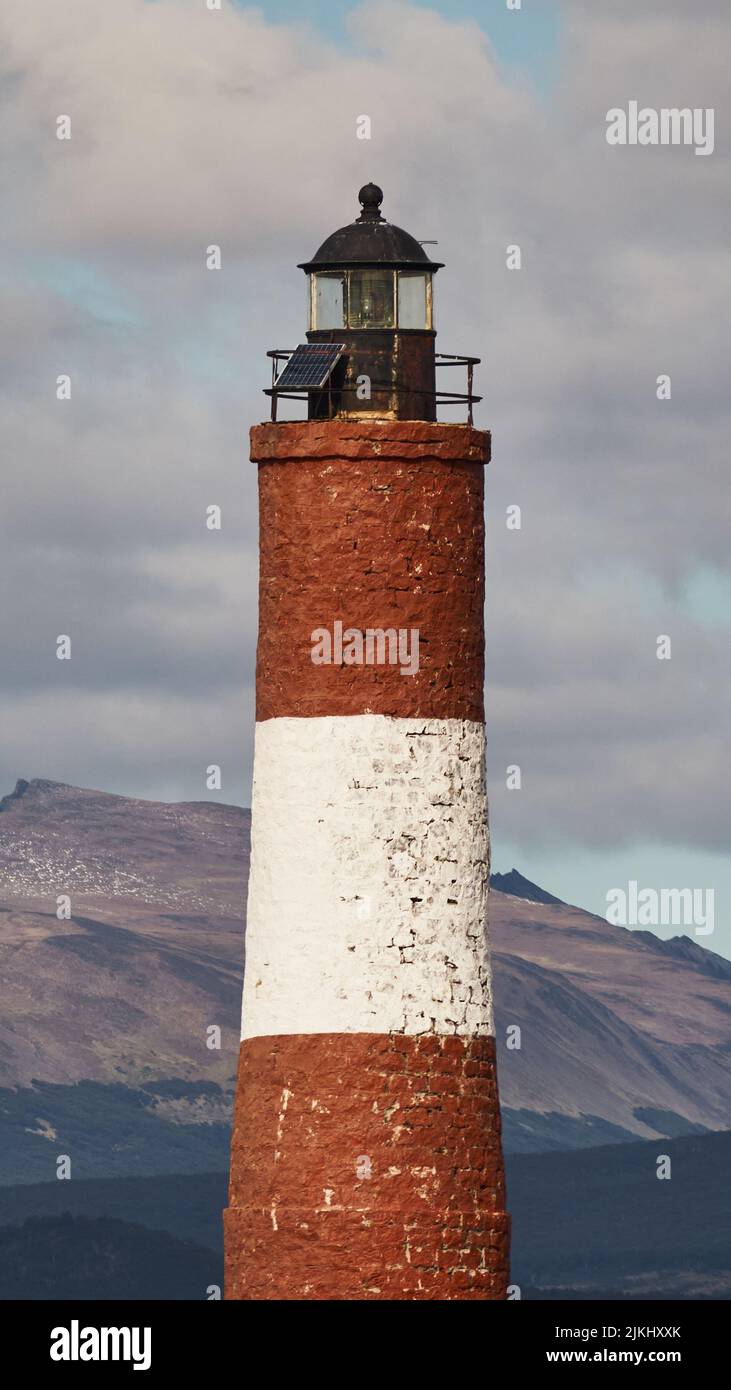 A vertical shot of a lighthouse in the background of mountains Stock ...