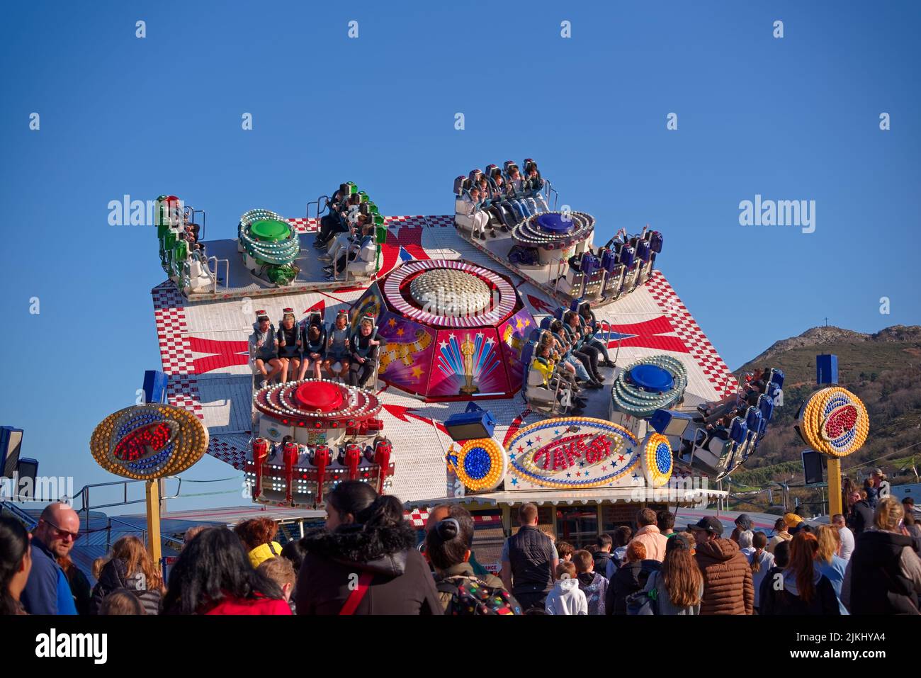 People enjoy fairground ride on "Take Off" carousel spinning in a sharp ...