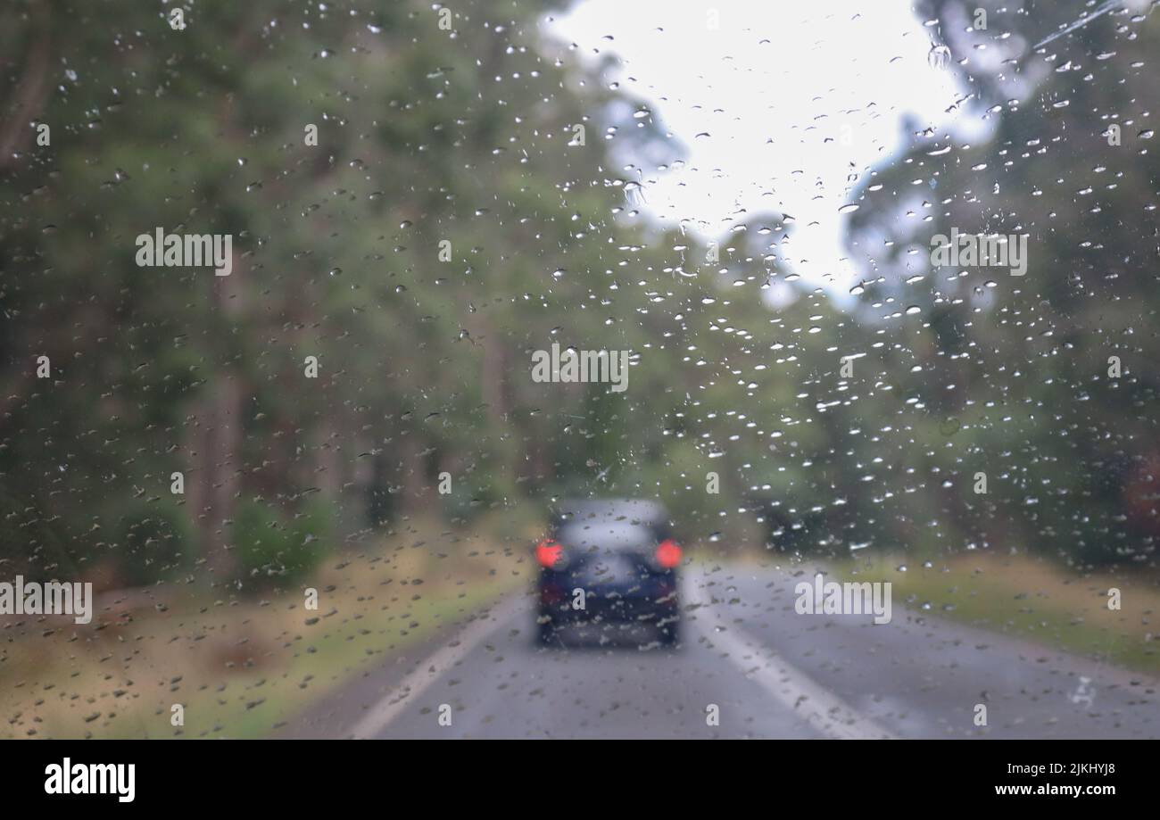 A driving car in wet weather with raindrops on windscreen Stock Photo ...