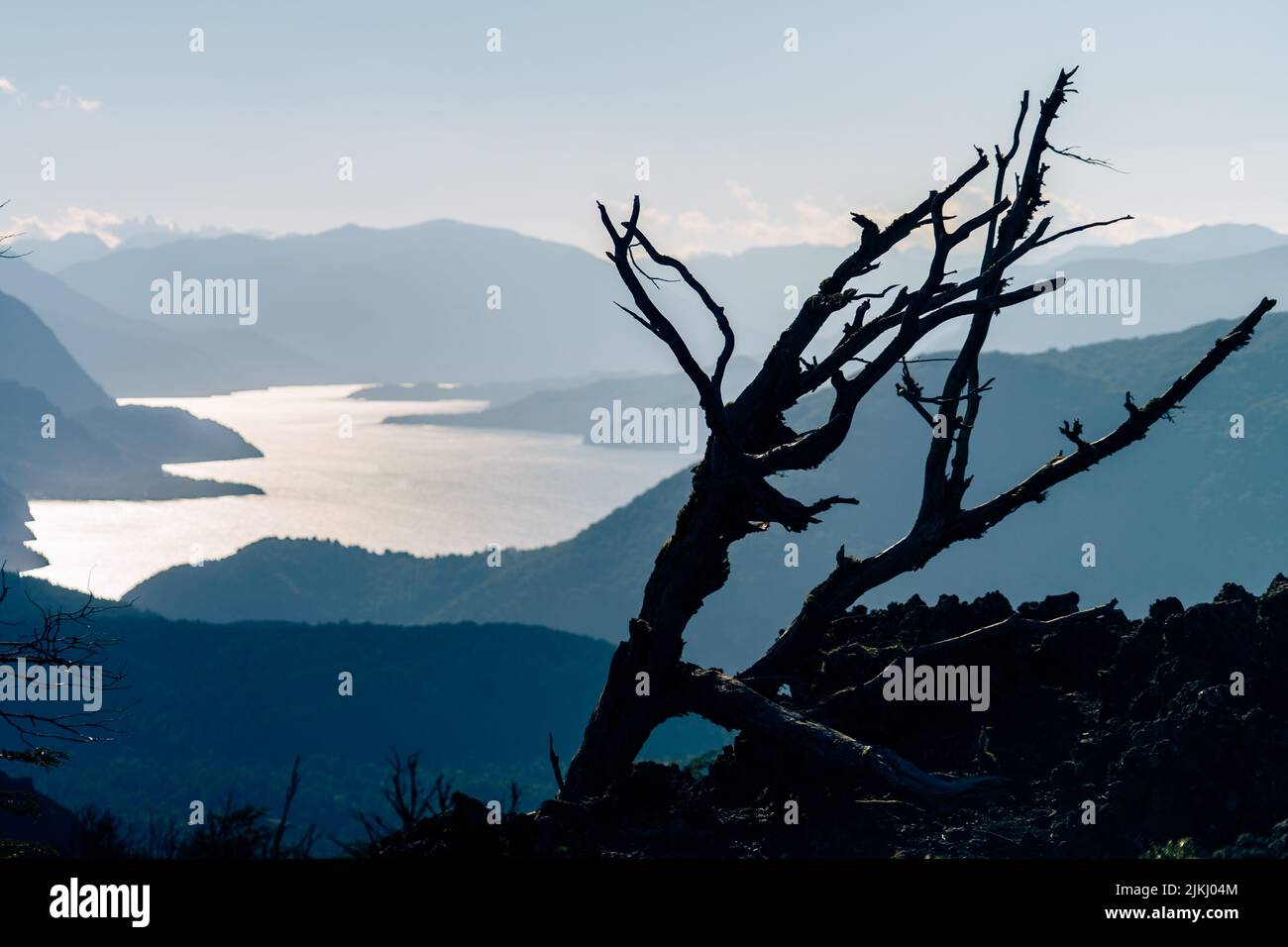 A lake surrounded by dense trees and mountains Stock Photo - Alamy