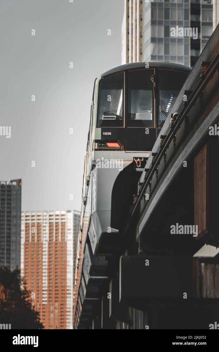 A low angle shot of the train in Japan with residential towers in the ...