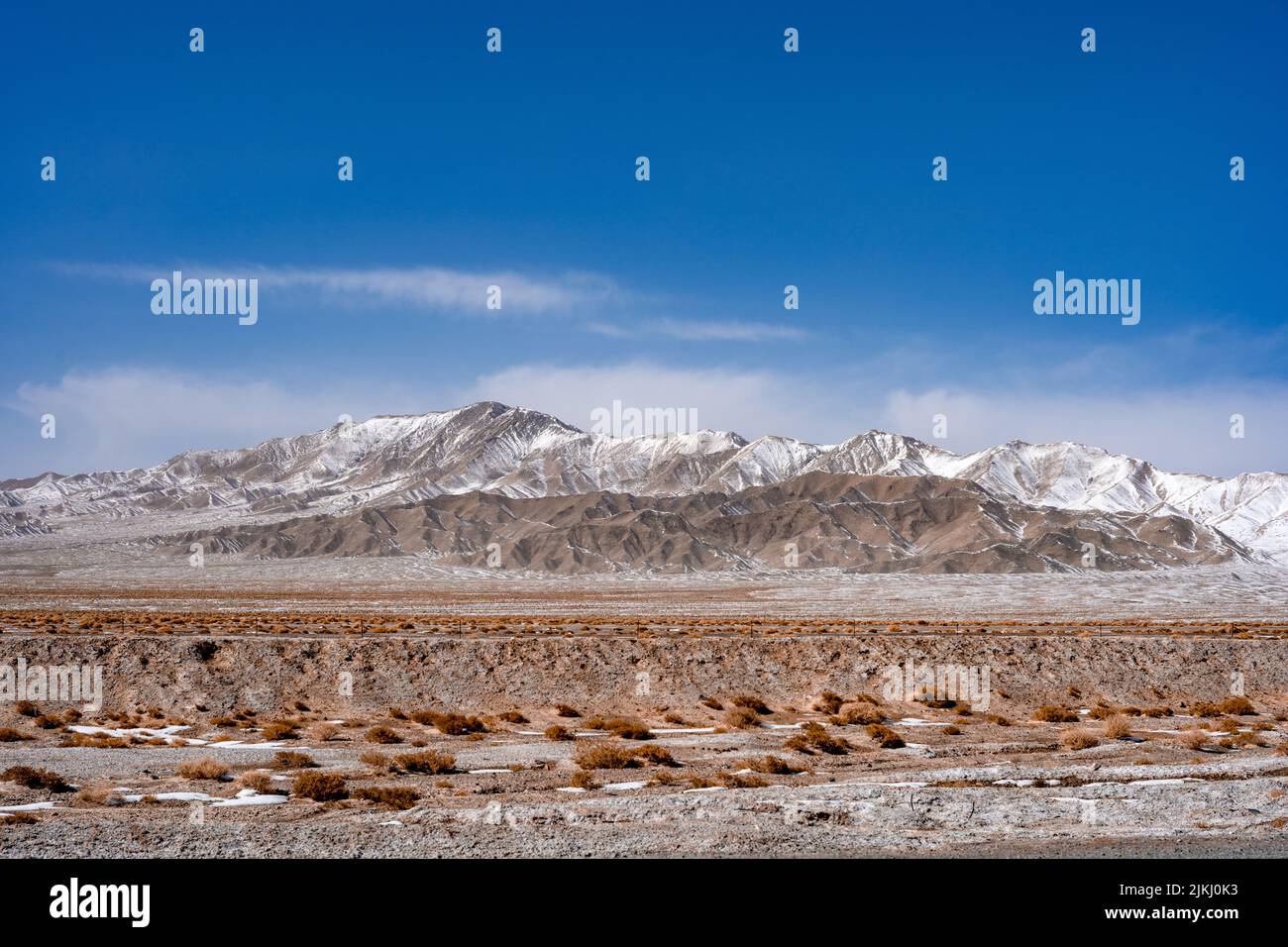 A deserted area and mountain range with snowy peaks in a distance Stock ...