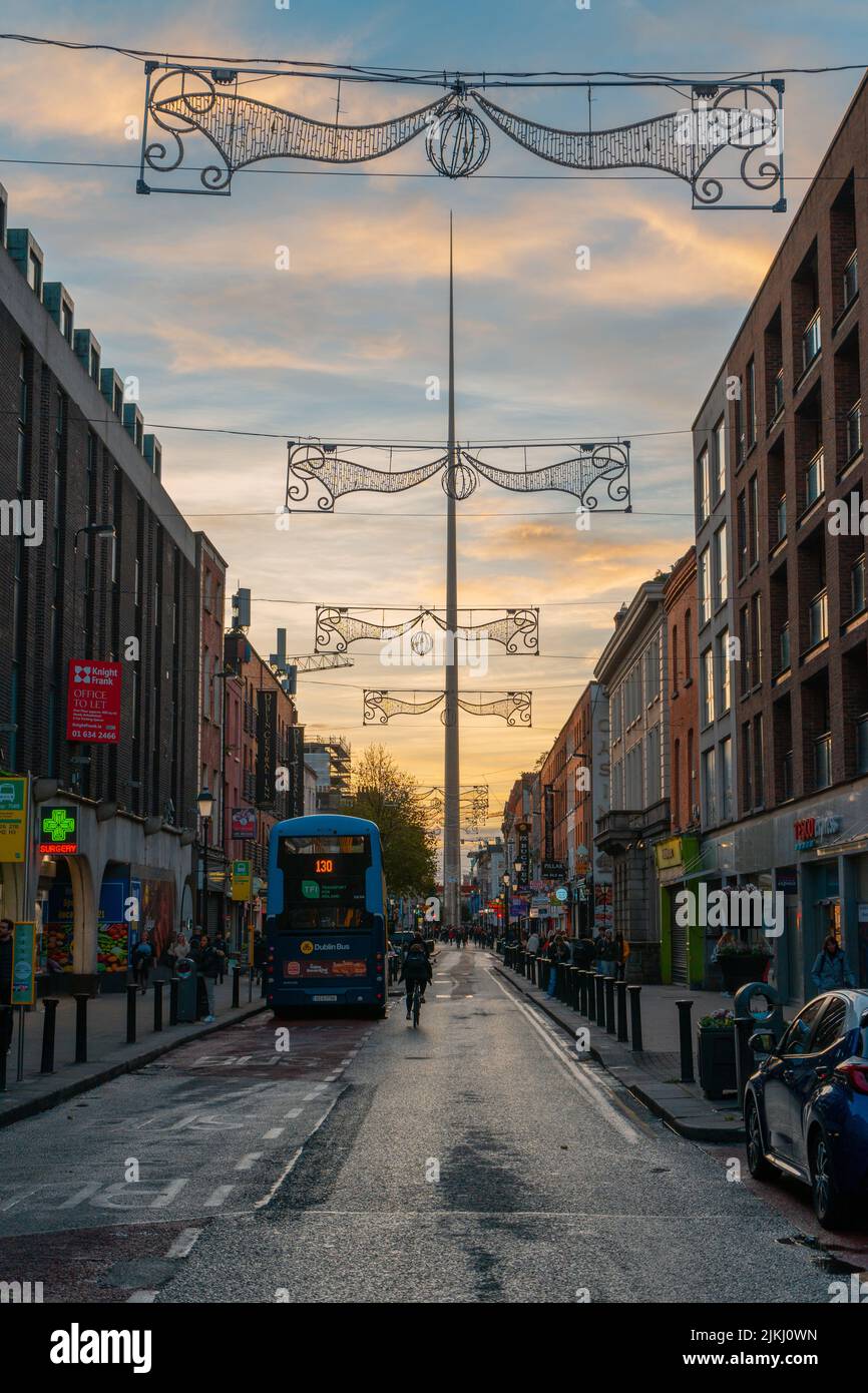 A vertical shot of a street with buildings with Christmas lights, and a ...