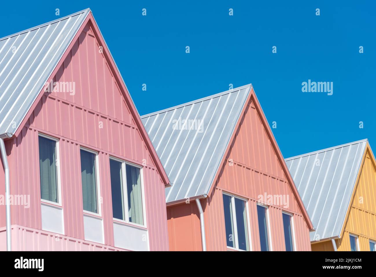 Lookup view of metal roof and gutter on row of new development colorful ...