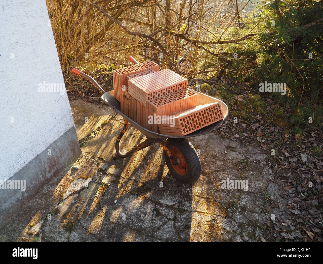 A shot of a wheelbarrow with a stone bricks Stock Photo - Alamy