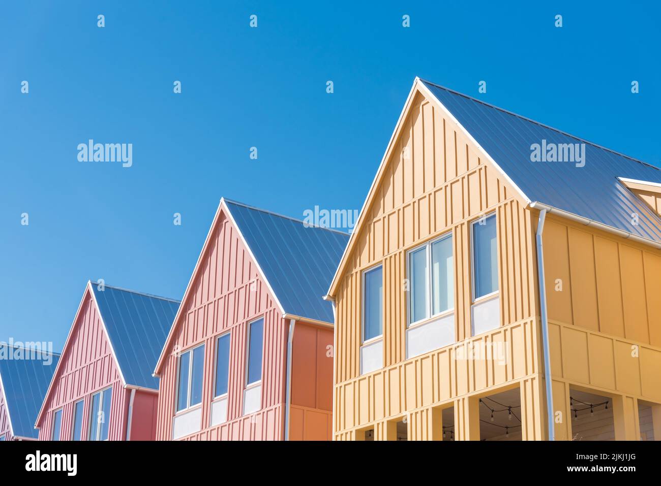 Lookup view of metal roof and gutter on row of new development colorful ...