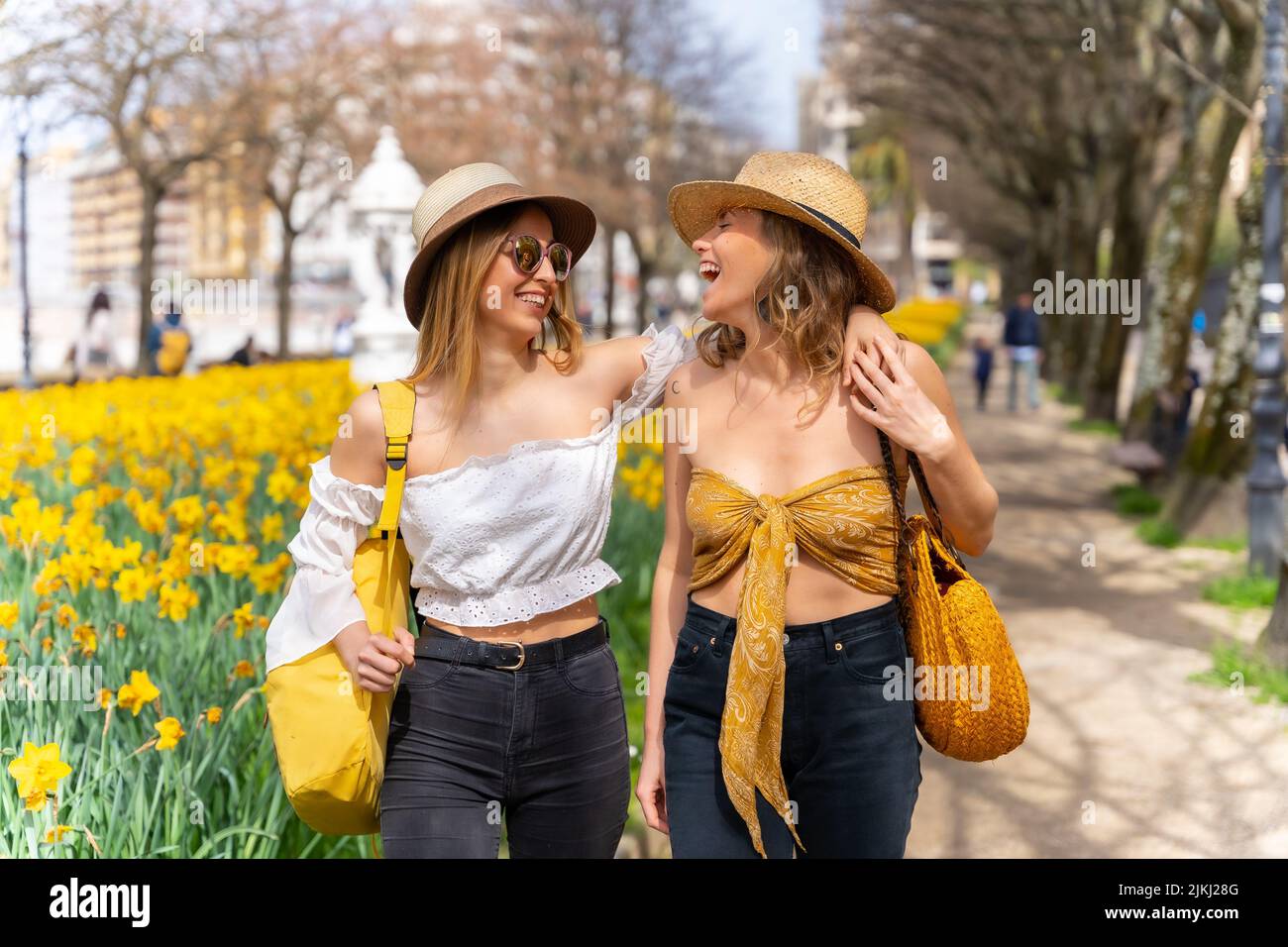 Friends in the city with straw hats walking and smiling next to some ...