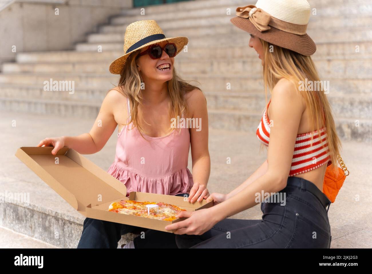 Friends eating pizza in the city enjoying the holidays, hugging and ...