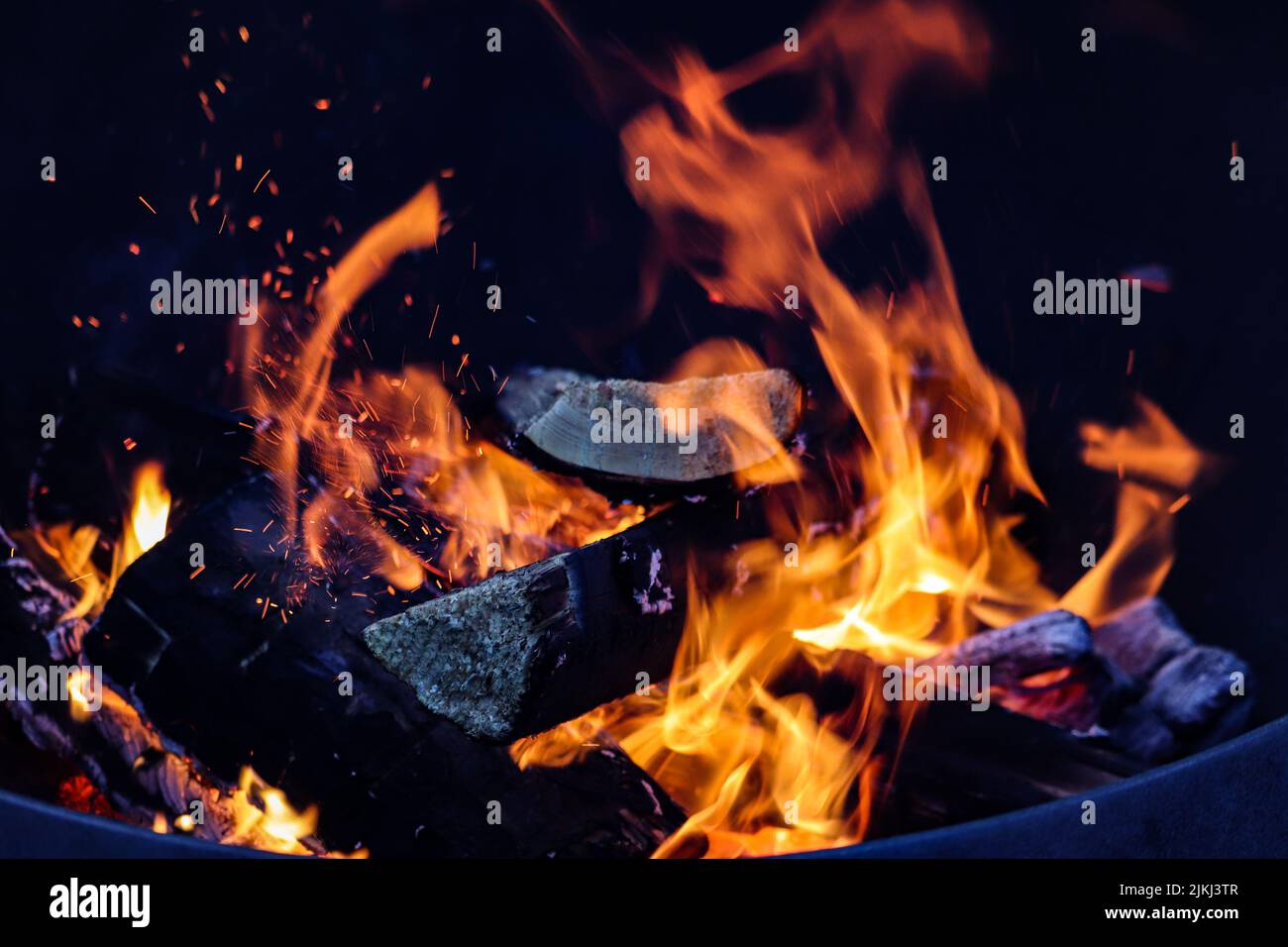 A closeup shot of wooden logs burning in a campfire during winter to ...
