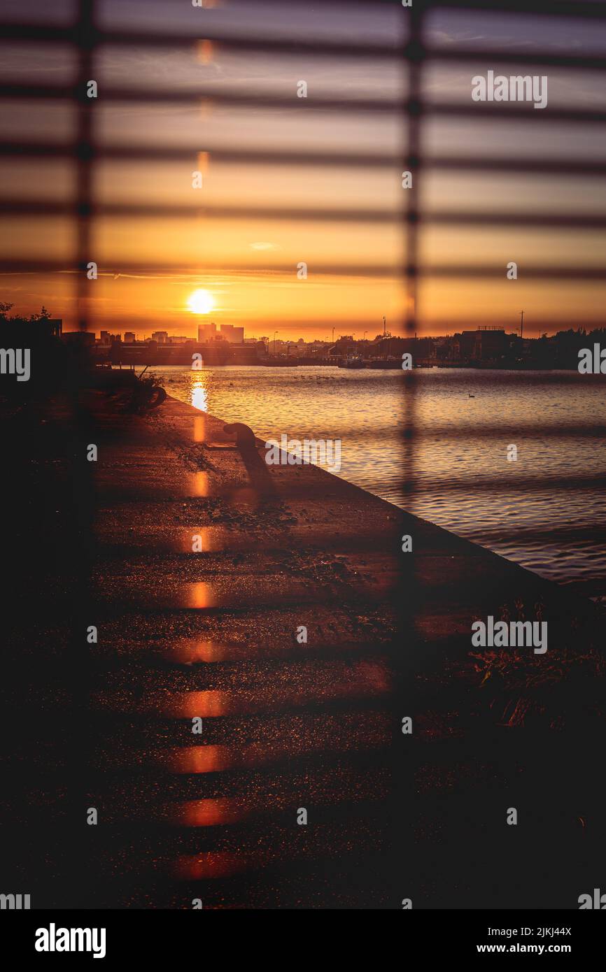 A beautiful sunset view over the river on window blinds background in ...