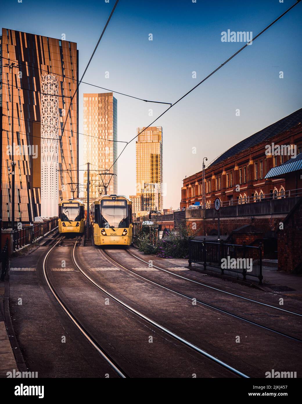 Two metrolink trams passing through Manchester City Center on a warm ...