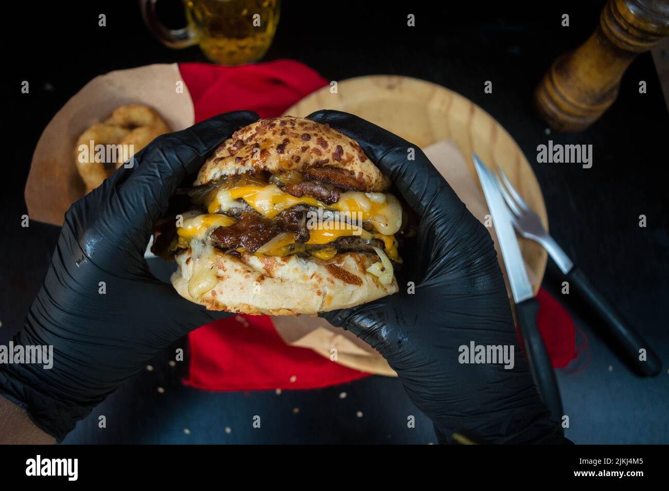 A man's hands in black rubber gloves holding tasty burger Stock Photo ...