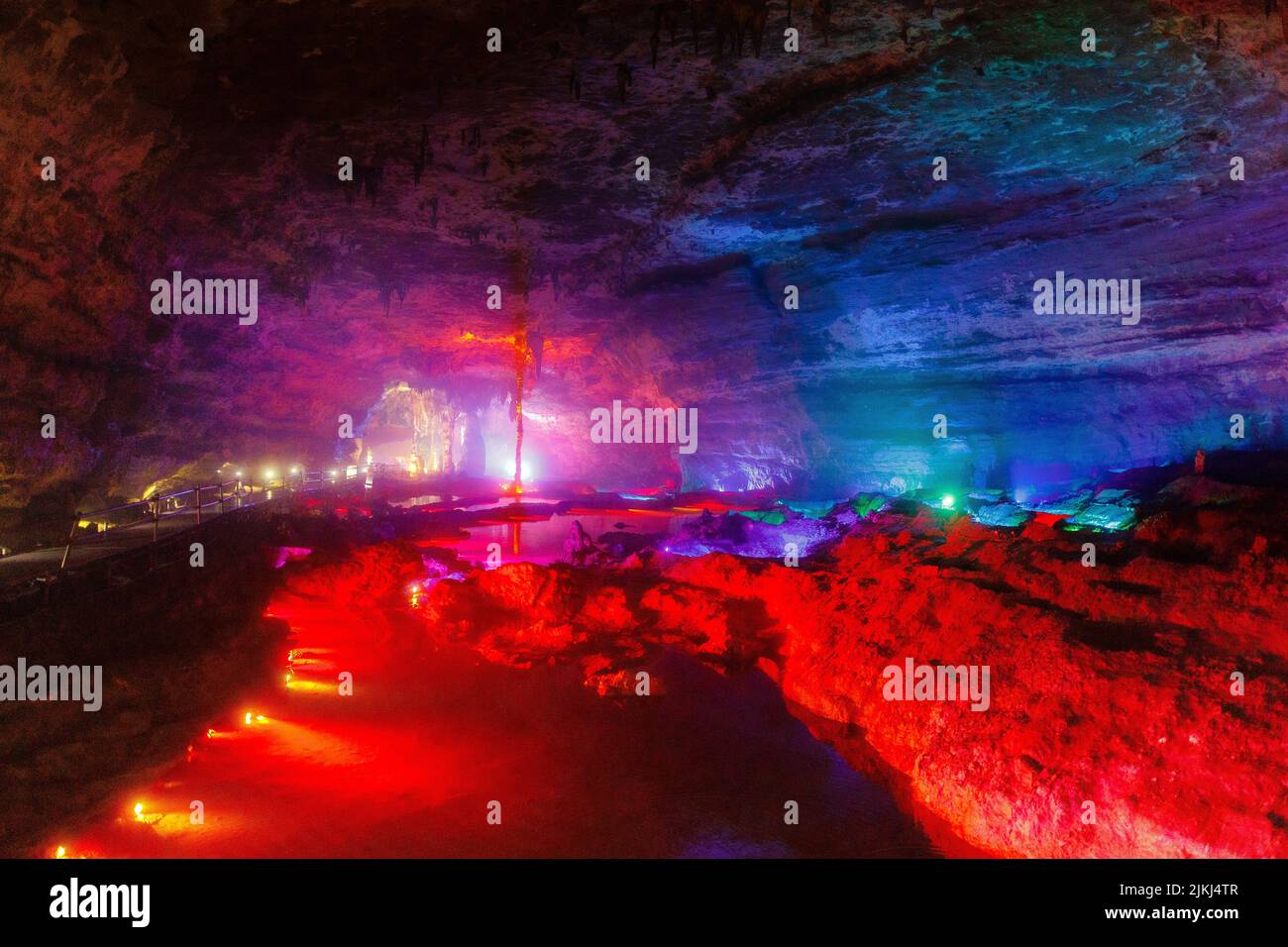 A scenic inside view of the Shuanghedong Caves with colorful lights ...