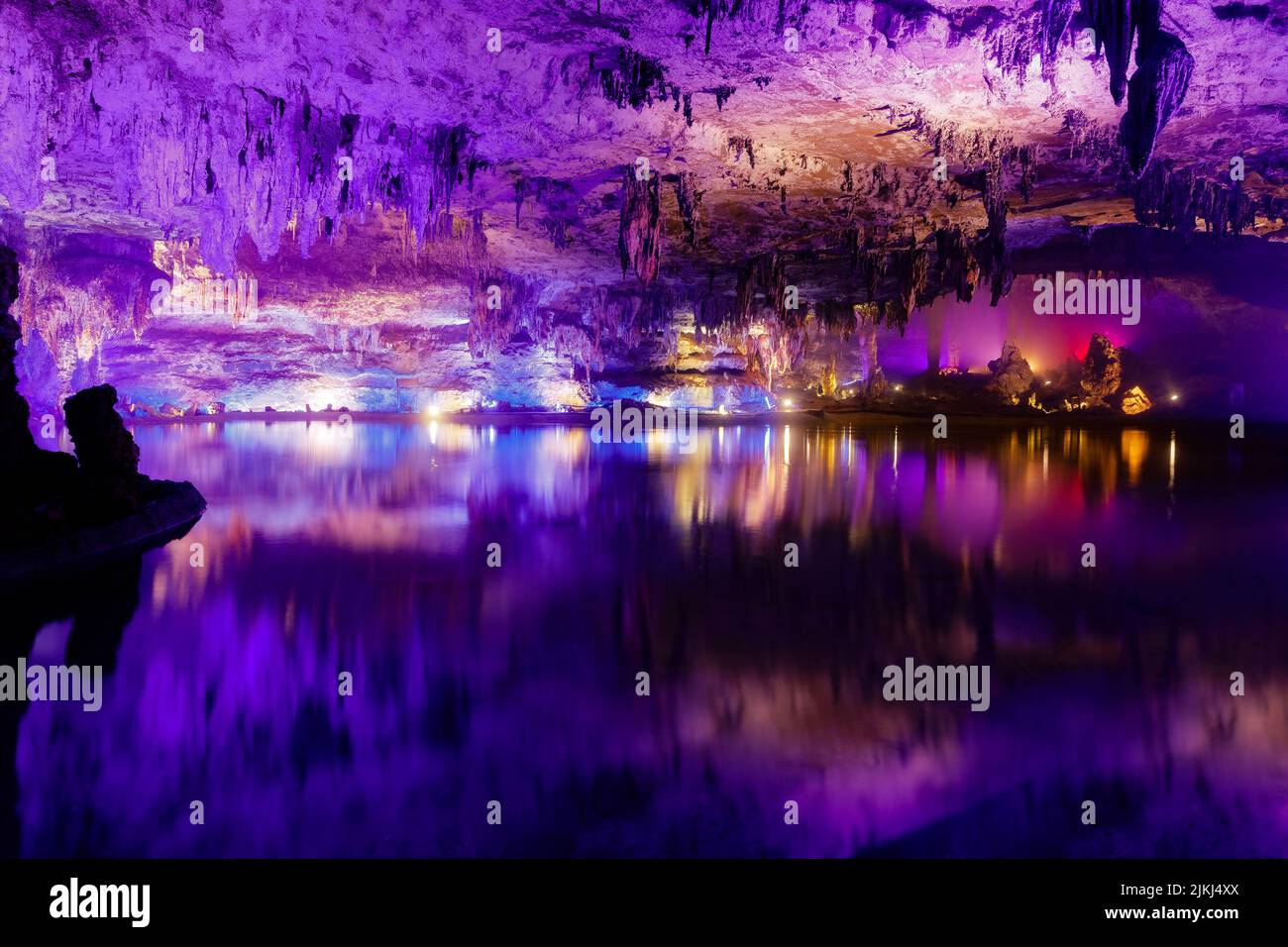 A scenic inside view of the Shuanghedong Caves with colorful lights ...
