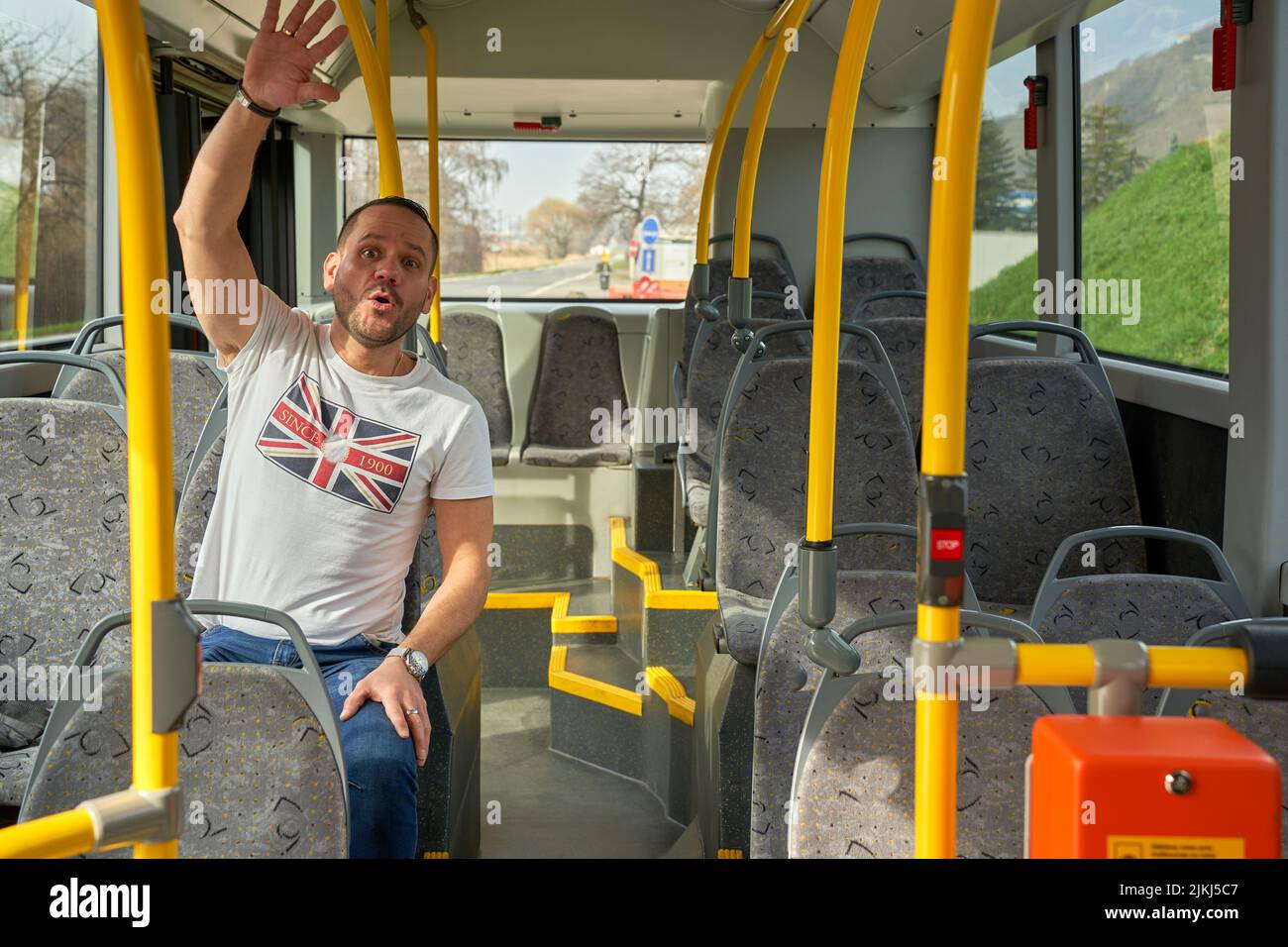A male passenger asking the driver to stop the bus with a hand gesture ...