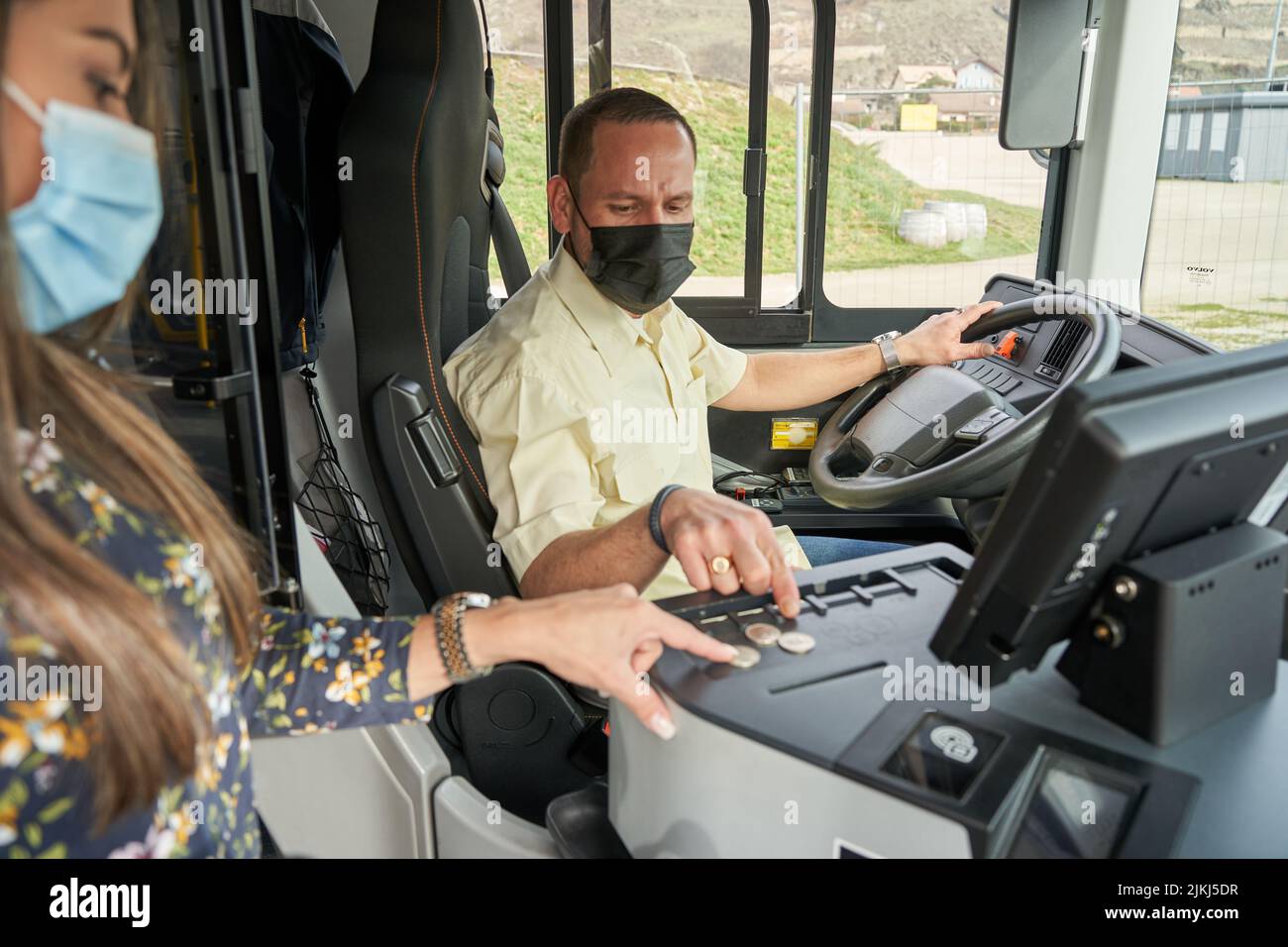 The passenger pays the bus driver for the trip Stock Photo - Alamy