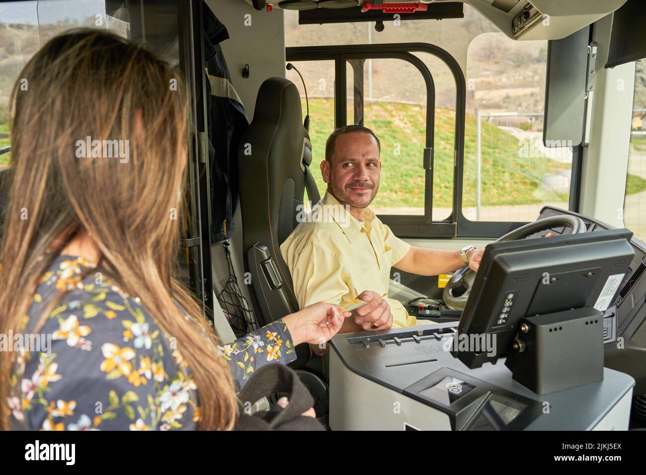 The passenger pays the bus driver for the trip Stock Photo - Alamy