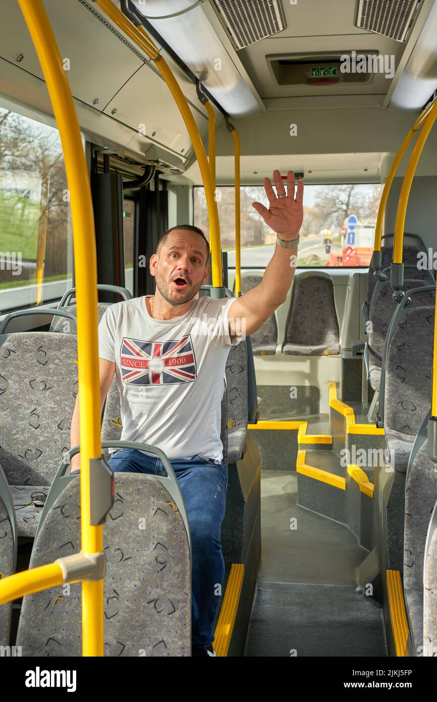 A vertical shot of a male passenger asking the driver to stop the bus ...