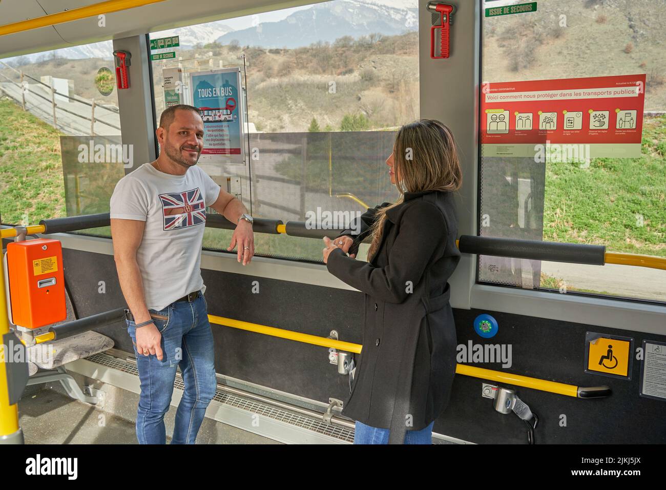 Two passengers standing and talking in a bus during the ride Stock ...