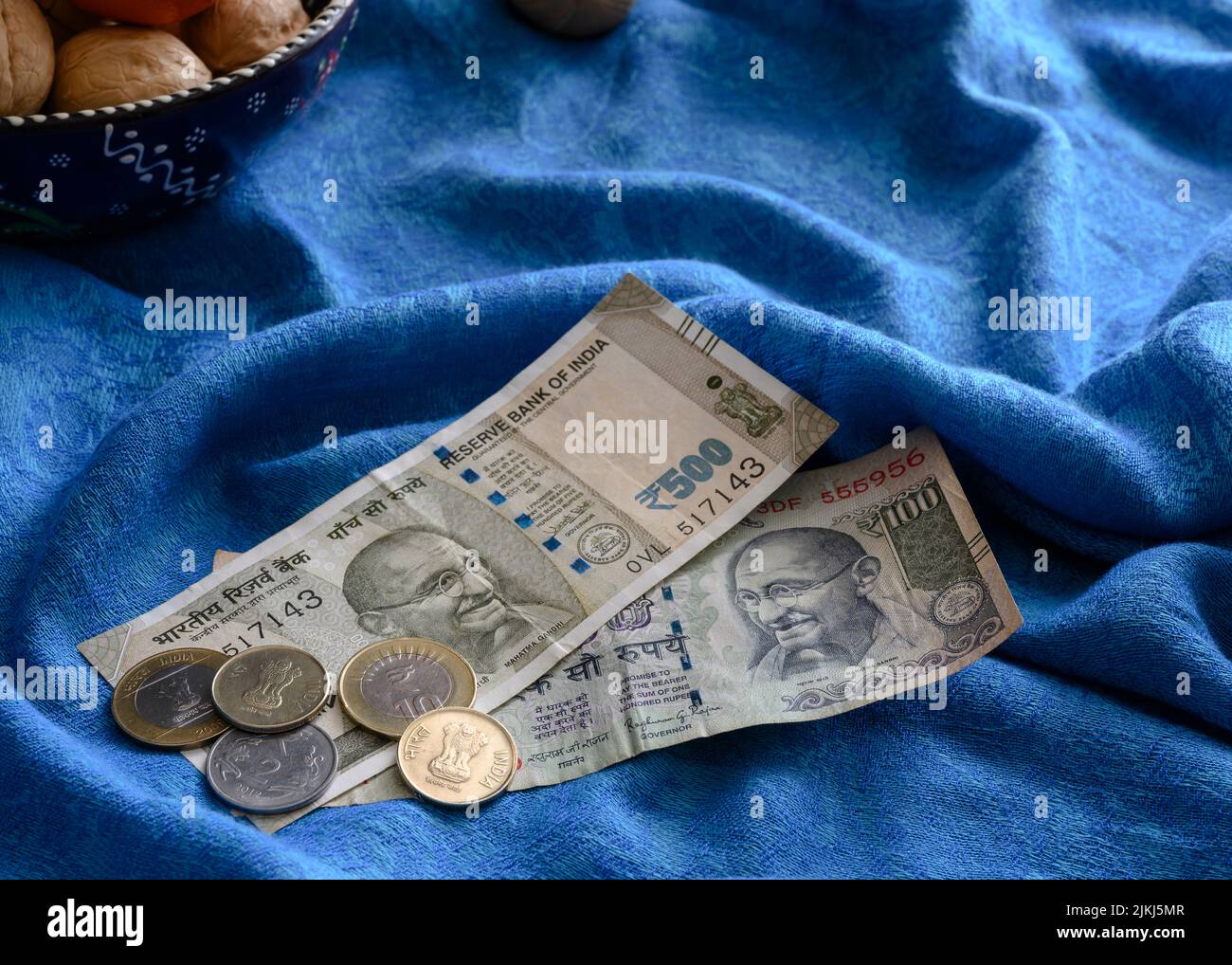 Coins and paper banknotes of Indian rupees on a background of blue ...
