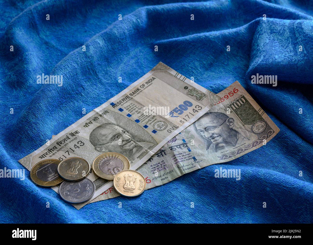 Coins and paper banknotes of Indian rupees on a background of blue ...