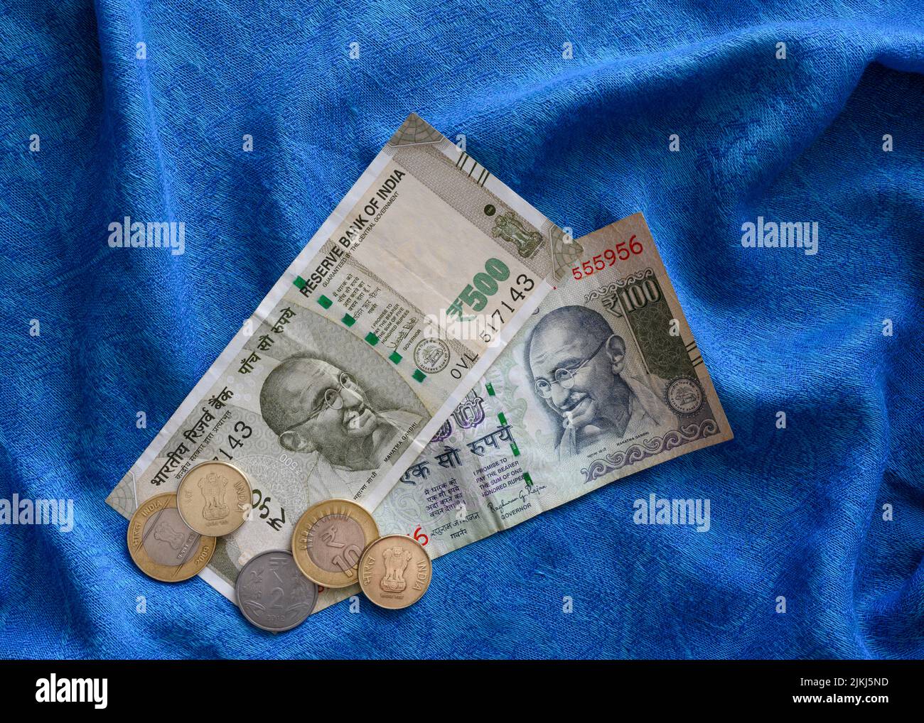 Coins and paper banknotes of Indian rupees on a background of blue ...