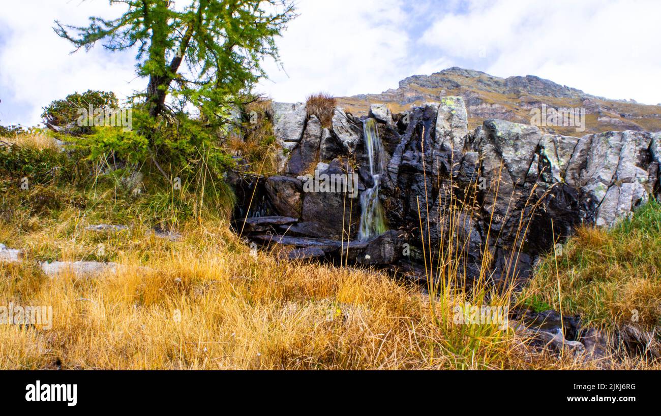 A view of a field in the background of a huge cliff in the daytime ...