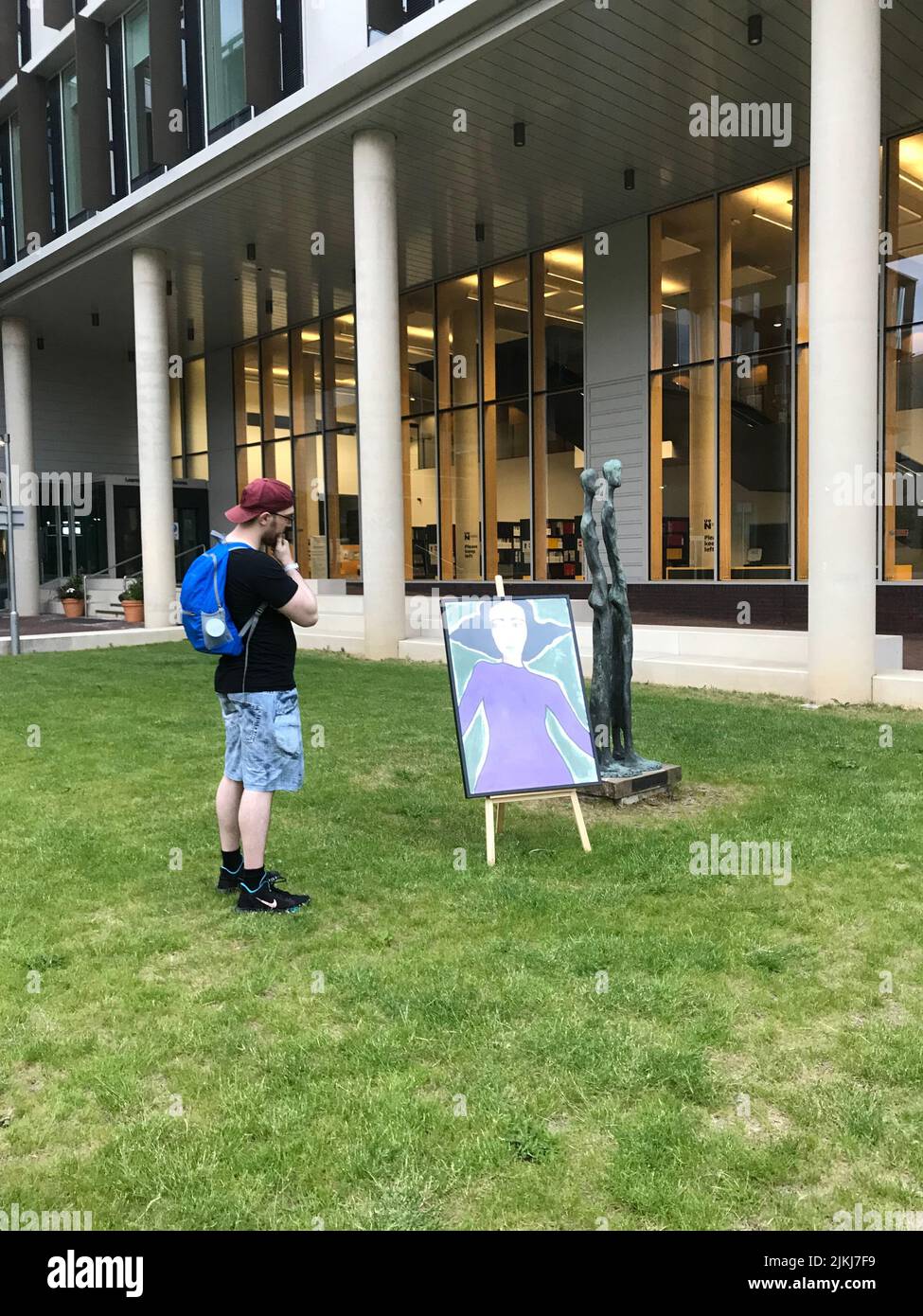 A vertical shot of art painting on stand in a university courtyard ...