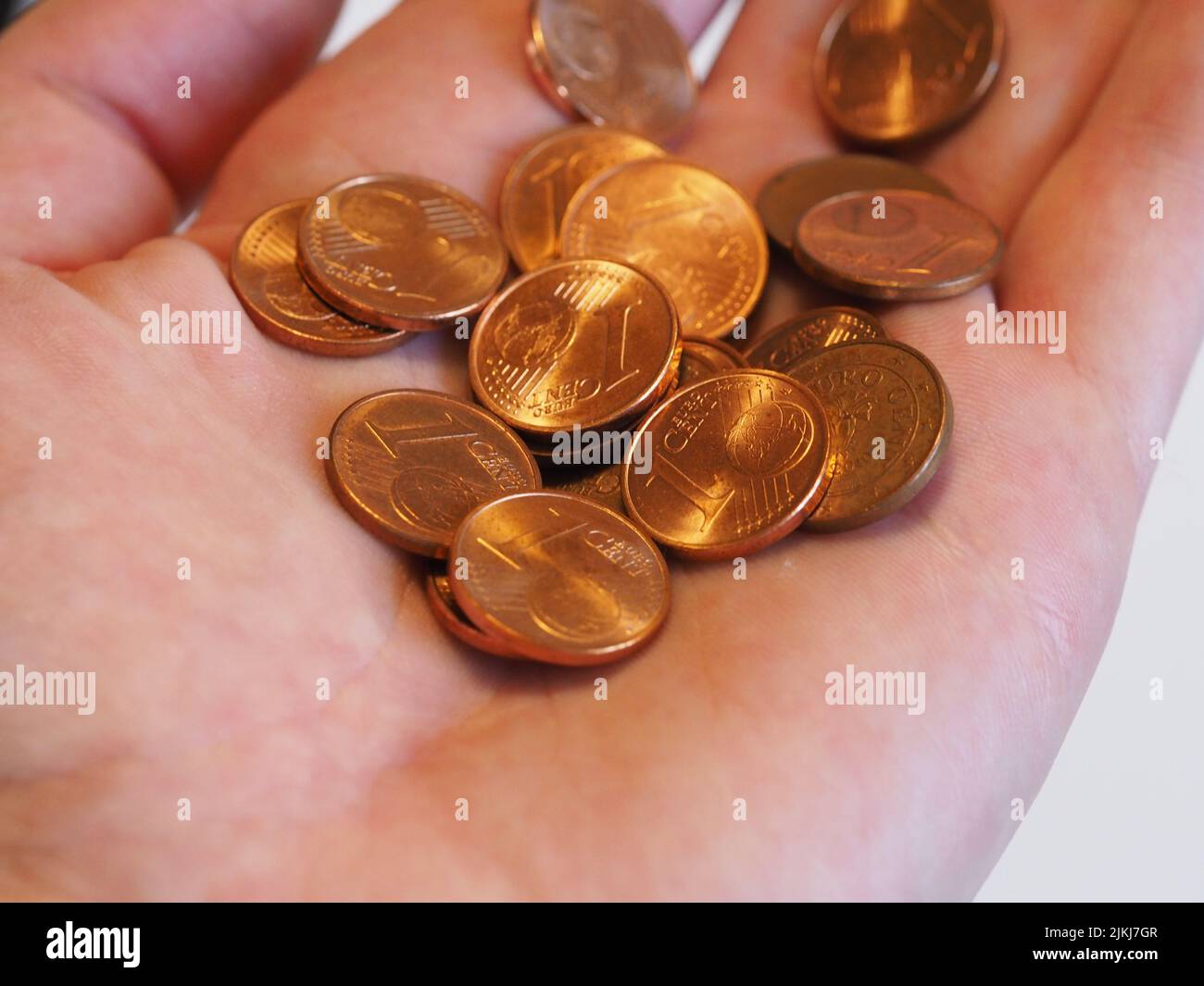 Hand holding shining 1 Cent Coins, white background Stock Photo - Alamy