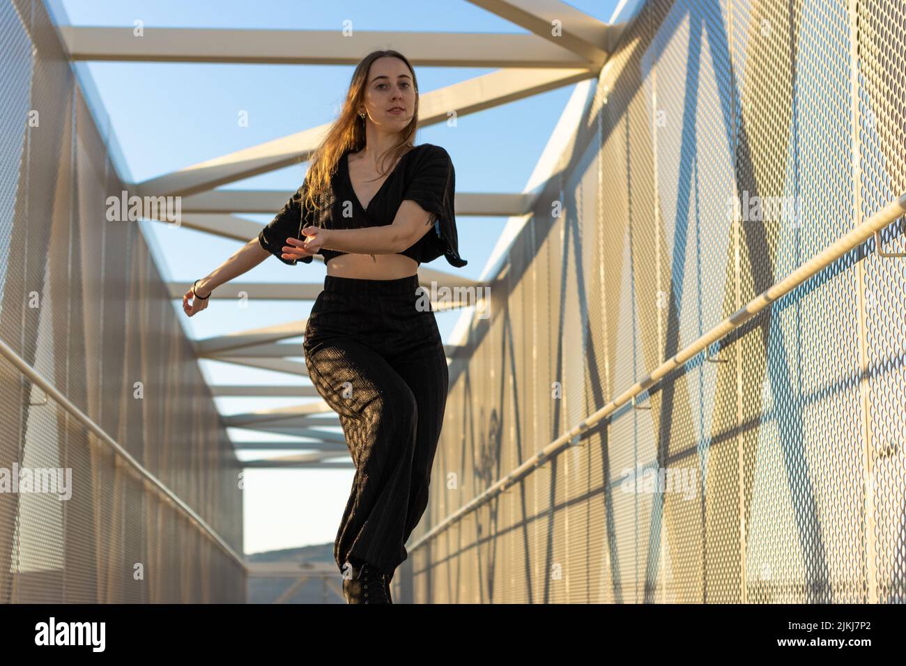 portrait of a young caucasian woman dancing urban dance at sunset on a ...