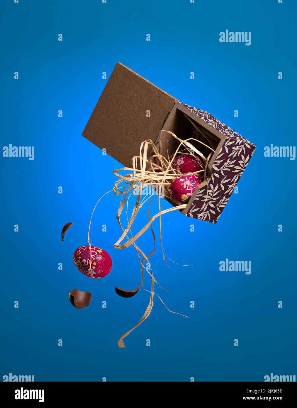 A vertical shot Chocolate Easter eggs falling off a box Stock Photo - Alamy