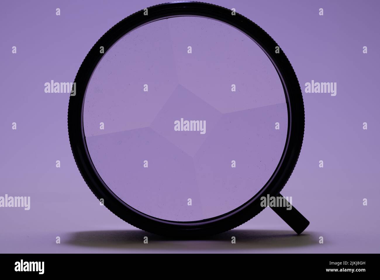 An illustration of a black magnifying glass on a purple background ...