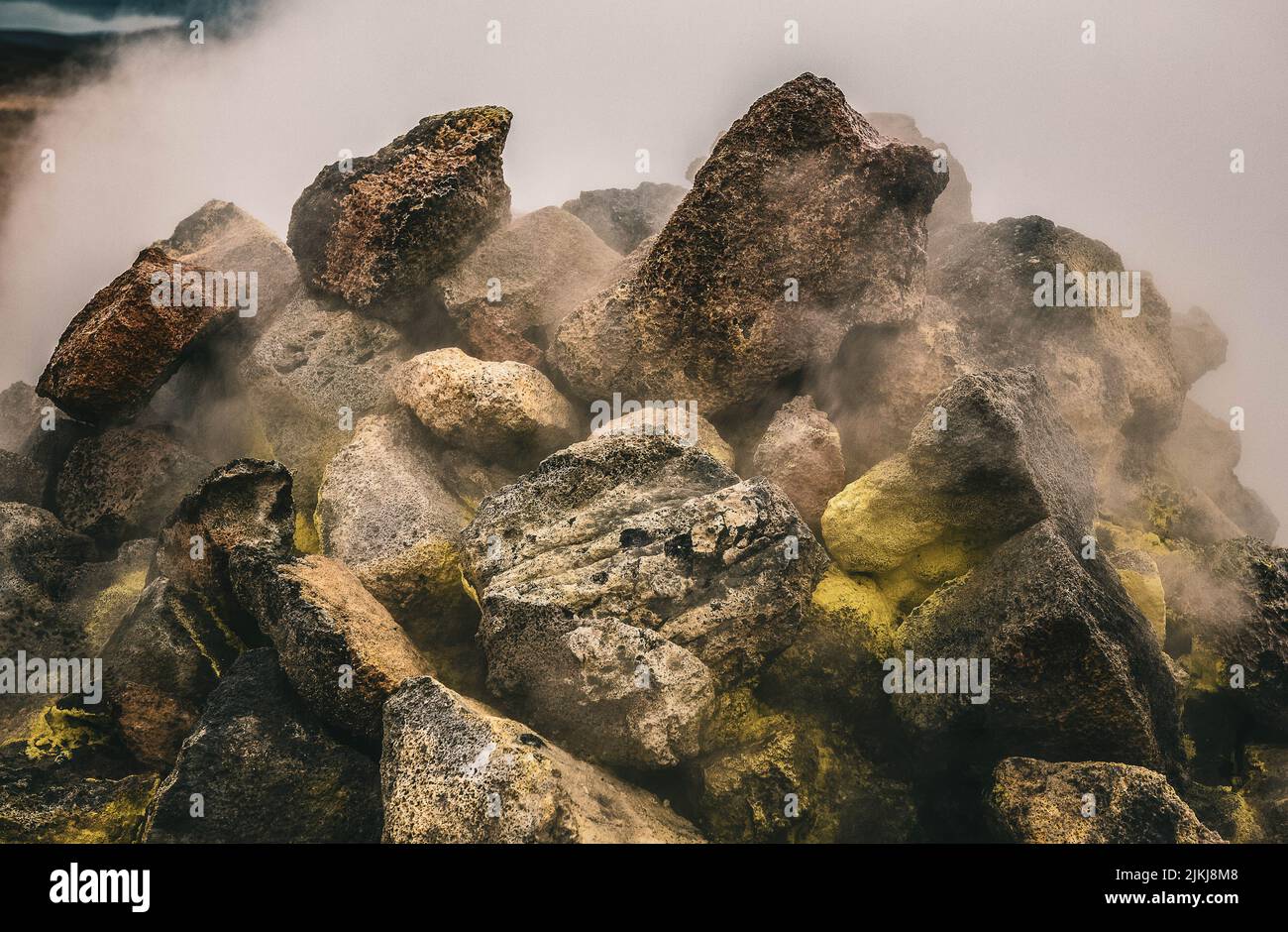 A closeup shot of mound of hot stones giving off sulfuric gas ...