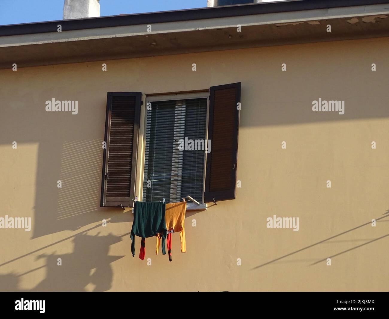 Drying clothes hanging outside on hanging clothes rope at the window of ...