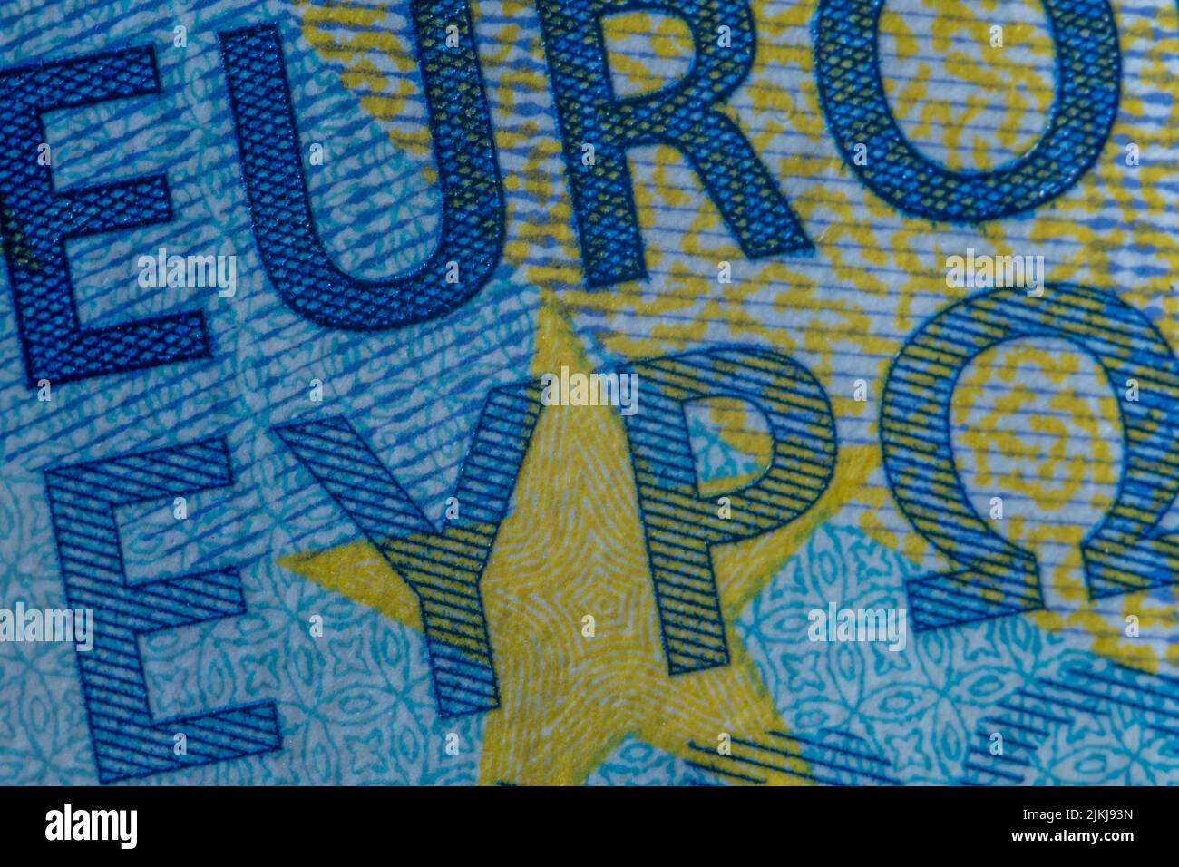 A macro focus shot of blue Euro word and yellow star on the twenty Euro ...
