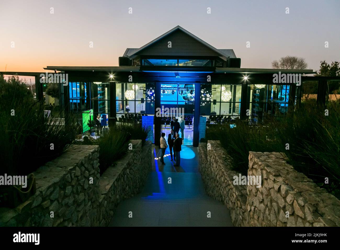 The exterior of an event venue at night with people in front of the ...