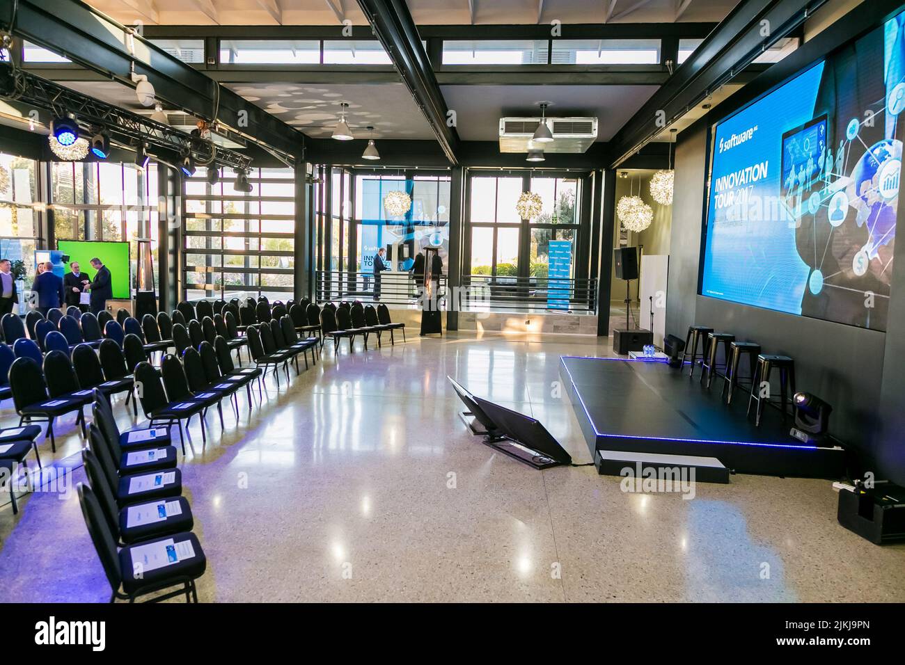 The interior of a conference event venue with black chairs and a big ...