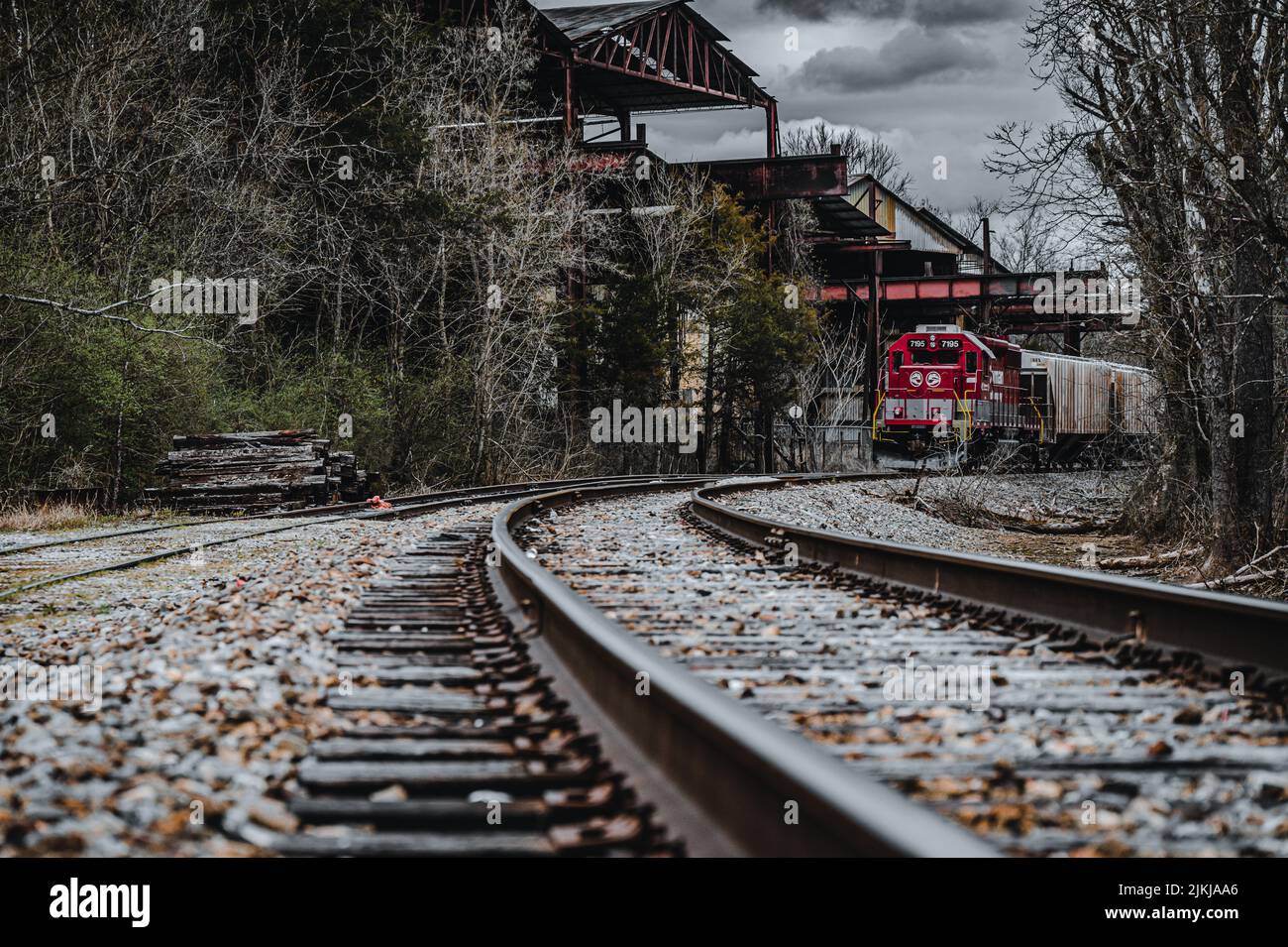 A view from the rails of a red locomotive arriving in the station Stock Photo - Alamy
