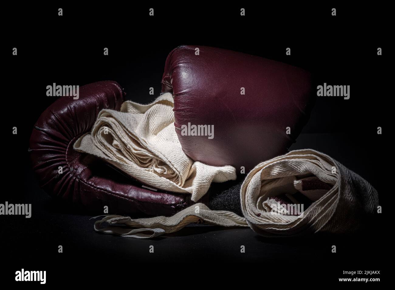 Boxing gloves and wraps in a low light room with black background Stock ...