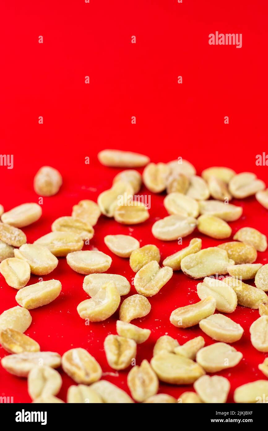 A vertical closeup of the bunch of roasted and salted peanuts isolated ...