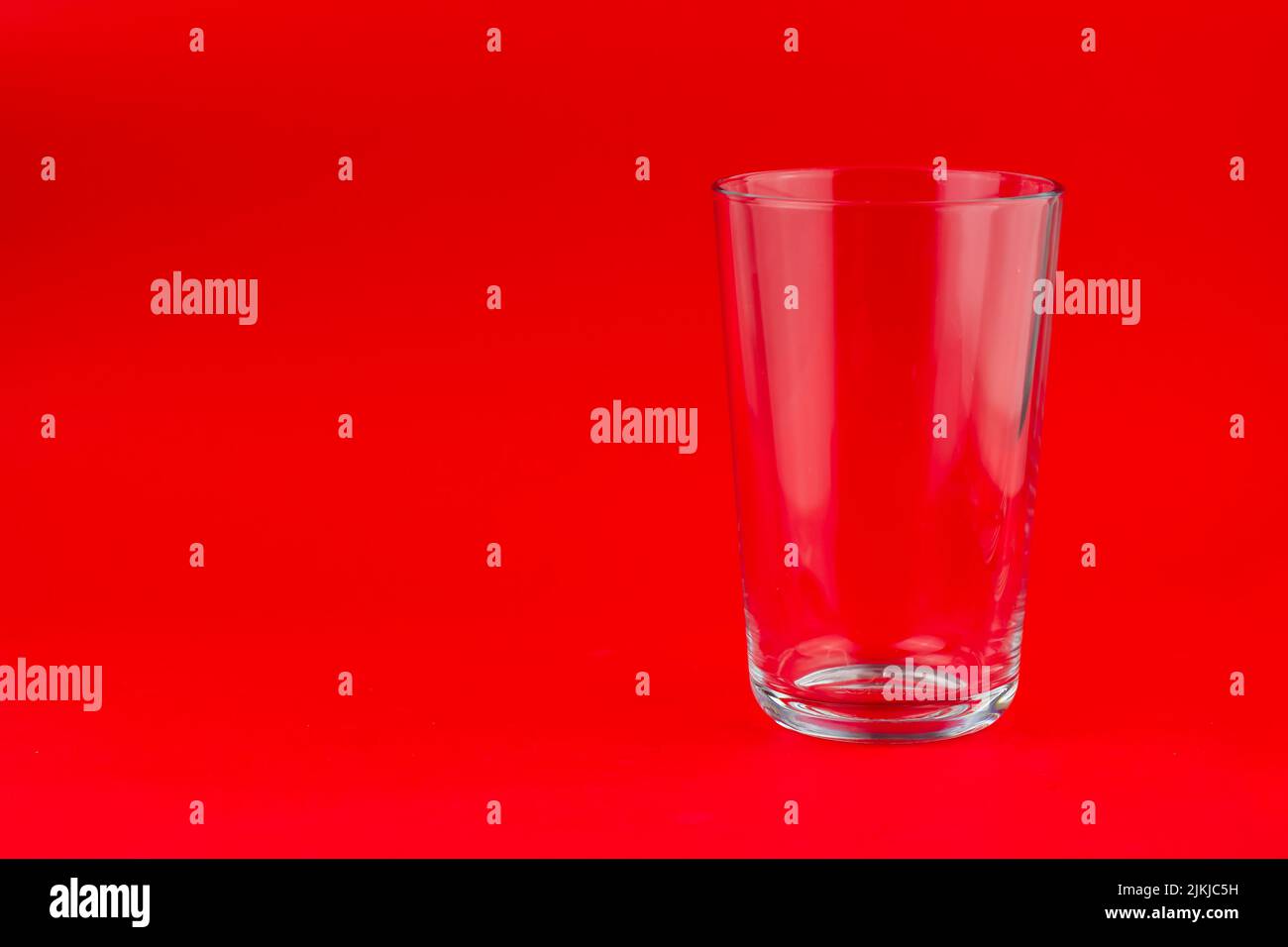 A closeup of an empty glass isolated on a red background Stock Photo ...