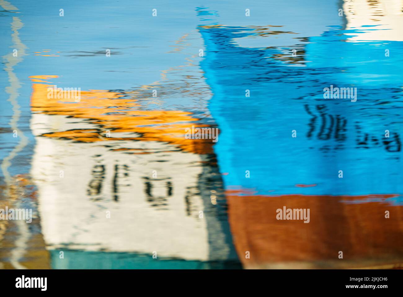 A closeup of colorful boats reflection in the water waves Stock Photo ...