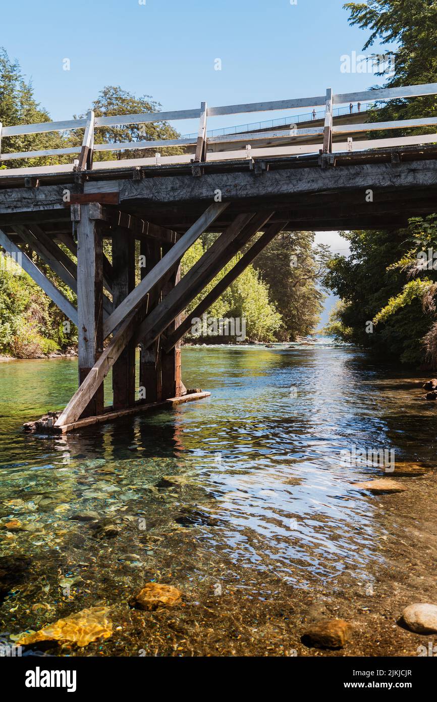 A bridge over a a river surrounded by trees in a mountainous area Stock ...