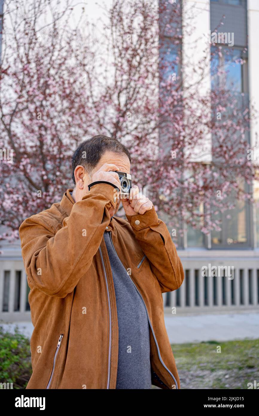 Older man enjoying his old film camera photographing the city Stock ...