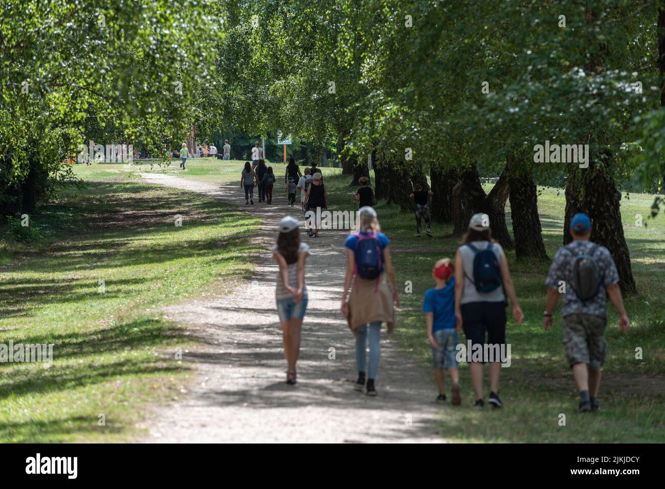 A rear view of visitors in basketball caps walking on the walkway in ...