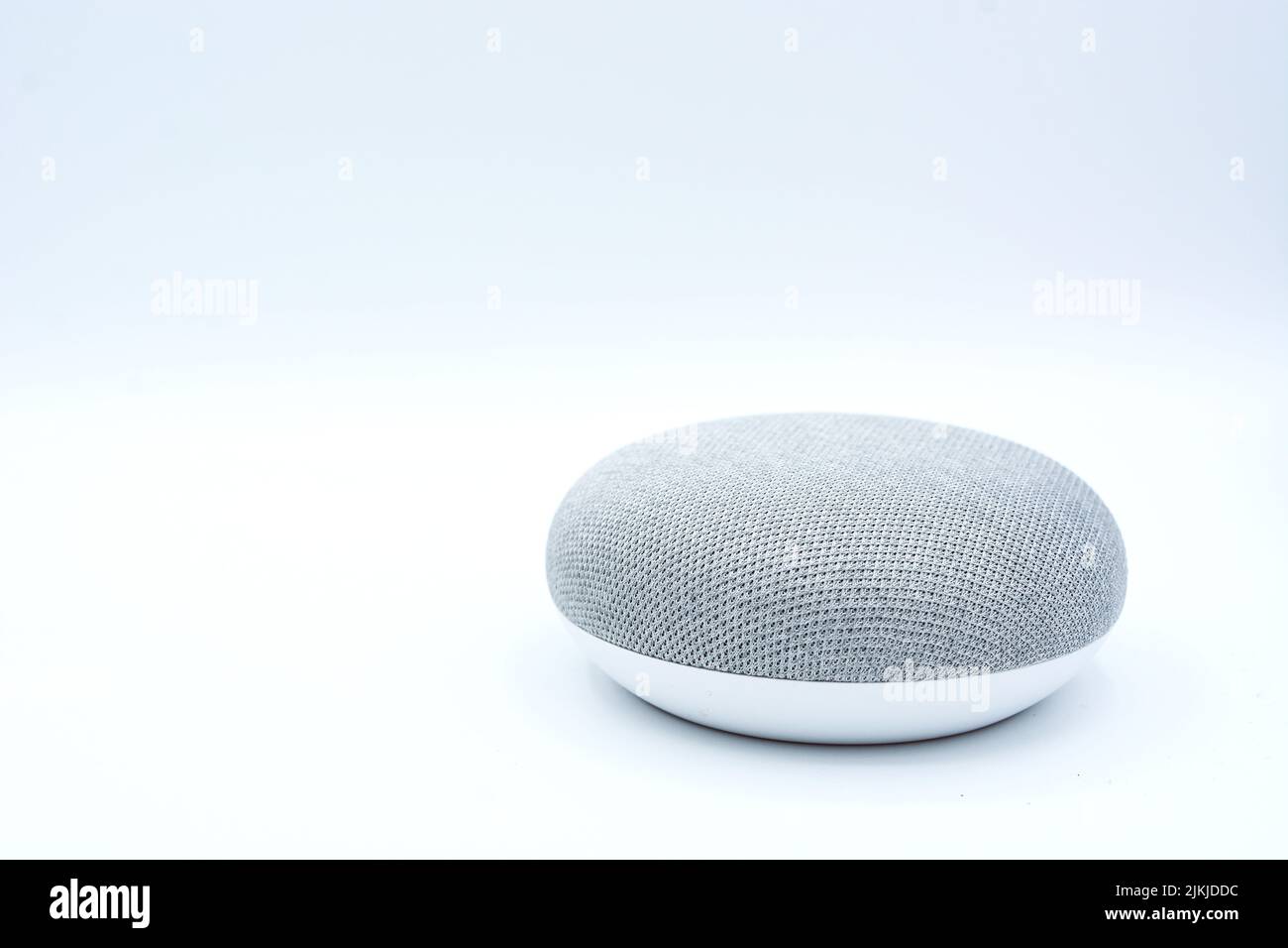 A closeup of an oval white and gray portable speaker isolated on a ...